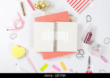 Girly pink desktop and stationery with blank notebook. Frame of ...