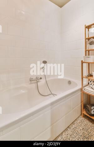 White bathtub placed in light bathroom with ceramic sinks and mirror ...