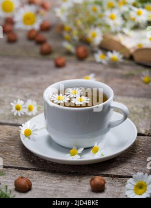 The chamomile tea in a glass cup on a wooden board Stock Photo - Alamy