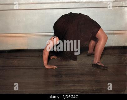 A young woman demonstrates how to perform 'physical jerks' (bending and ...