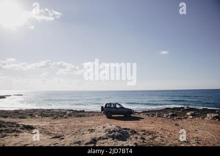 car parked near cliff edge in usa california with blue sky and sea ...