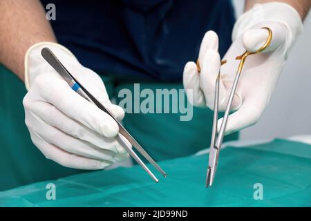 Forceps in doctor hand with disposable glove on white background ...