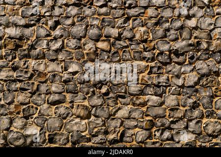 View of a big wall made of flint stones, building material in ...