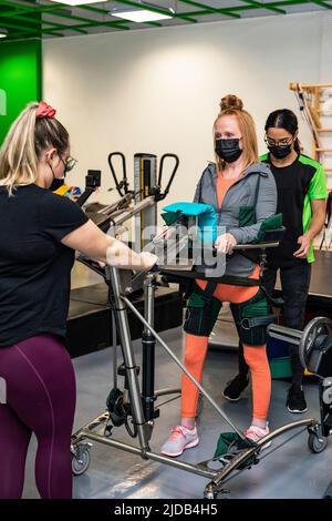 A paraplegic woman working out using an assisted walking machine with ...