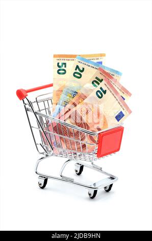 Stack of Euro banknotes with shopping cart in money consuming concept ...