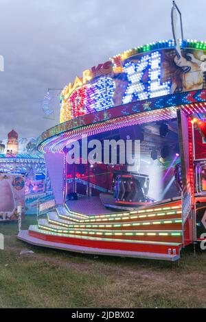 The Waltzer funfair ride in full swing, under an evening sky. The 140th ...