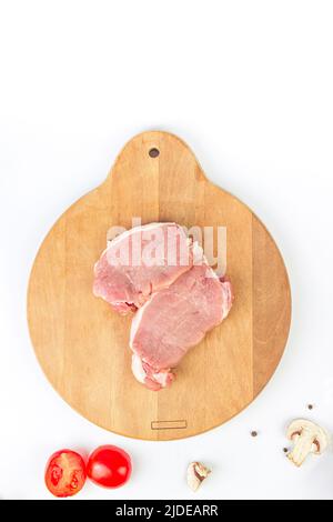 Raw steaks with spices and knife on wooden table. Preparation for lunch ...