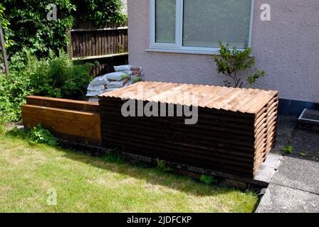 Stack of wooden fence panels, posts, gravel boards and cement mix ...