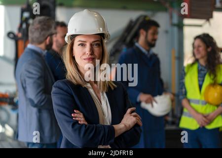 Portrait of female chief engineer in modern industrial factory looking ...