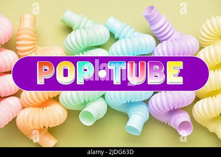 Different colorful Pop Tubes on orange background Stock Photo - Alamy