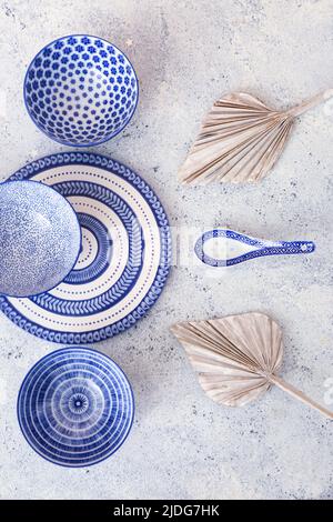 Stylish table setting and decorative palm leaf on light background ...