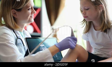 Doctor diagnosing injuries or defects of kid, little girl telling ...