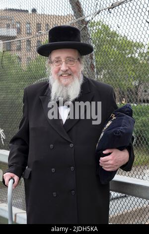 A posed portrait of an orthodox Jewish man dressed for Purim in a ...