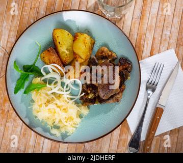 Rabbit liver dish with boiled potatoes and sauerkraut closeup Stock ...