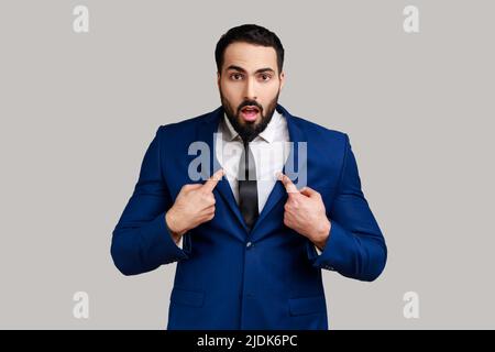 Happy and surprised man pointing at himself, smiling pleased, standing ...