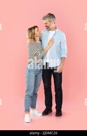 Caucasian man standing over pink background pointing aside with hands ...