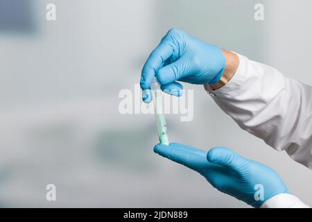 Doctor's hand with a test tube for stool sample for colon cancer ...