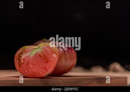 Beautiful fresh tiger tomatoes on dark background Stock Photo - Alamy