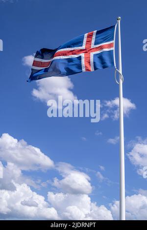 Icelandic flag blowing in the wind outdoors. Early evening cloudy sky ...