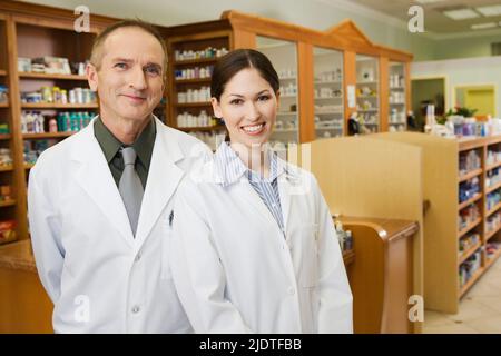 Portrait of two pharmacists - men and women in white coats in pharmacy ...