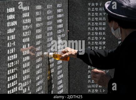 A bereaved family prays for victims at the Peace Memorial Park in ...