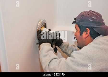 Plumbing installation crew putting in plastic and copper pipes into new ...