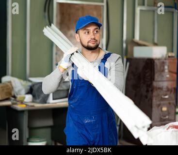 Worker carrying construction materials at renovating object Stock Photo ...