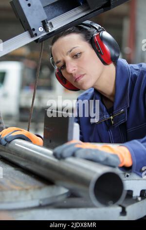 pretty woman next to pipes in factory Stock Photo - Alamy