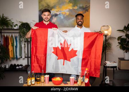 Happy young man with flag of Canada showing thumb-up on white ...