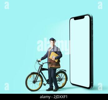 Young postman with bicycle and modern mobile phone on grey background ...