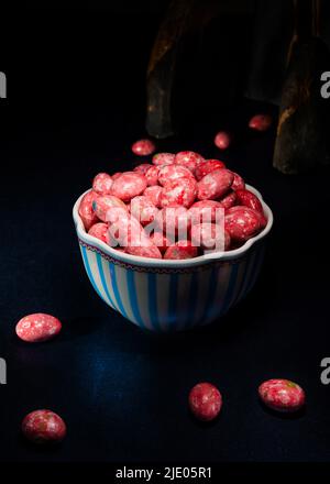 Chocolate dragees in crispy colored glaze. Dragee with almonds in a ...