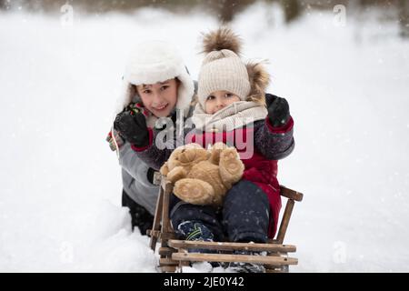 Two children on a wooden sleigh ride, Cortina d'Ampezzo, Italy 1954 ...