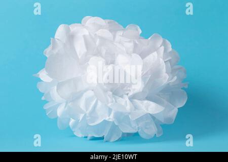 White flower made of thin white paper on a blue background Stock Photo ...