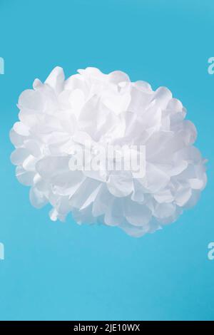 White flower made of thin white paper on a blue background Stock Photo ...