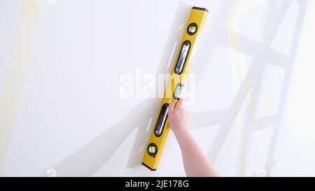 A construction worker checks the level of a block wall using a leveling ...