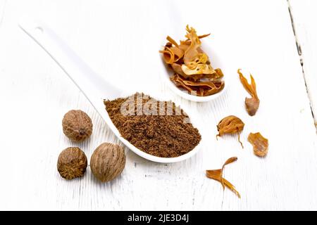 Dried nutmeg arillus and ground nutmeg in two spoons, whole nuts on ...