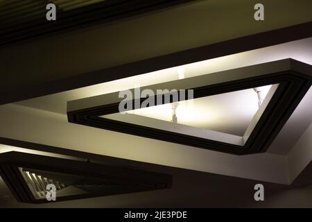 Triangular lamp in interior. Design of lighting device. Lamp on ceiling ...