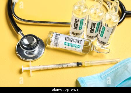 Monkeypox vaccine, syringe and stethoscope on yellow background ...