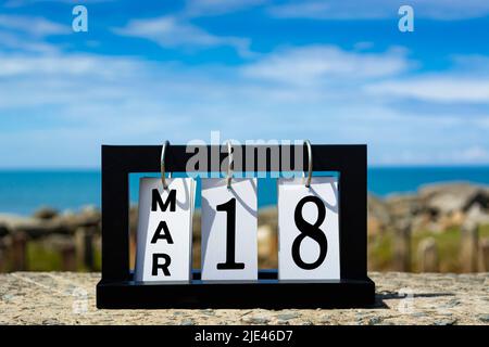 Text 18 MAR on wooden cubes on BLUE background. Date. Square wood ...