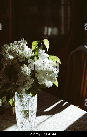 Vase with lilac flowers in room Stock Photo - Alamy