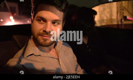 People inside car backseat at night. Man and woman riding taxi cab ...