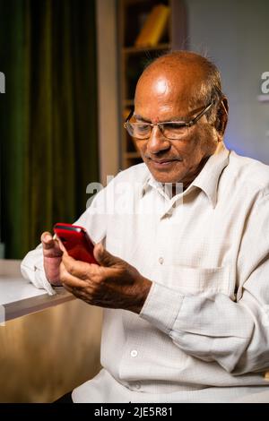 Indian Senior man or grandpa reading book with granddaughter or grand ...
