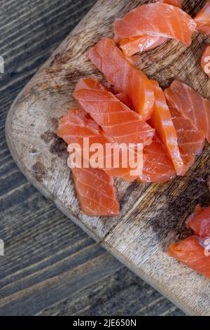 sliced red salted salmon during cooking, cutting fish fillets during ...