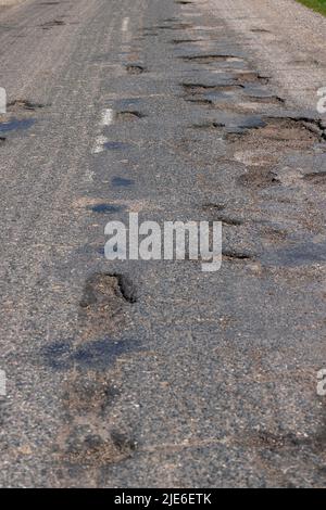 poor paved road with a lot of holes and potholes, poor transport ...