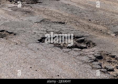 poor paved road with a lot of holes and potholes, poor transport ...