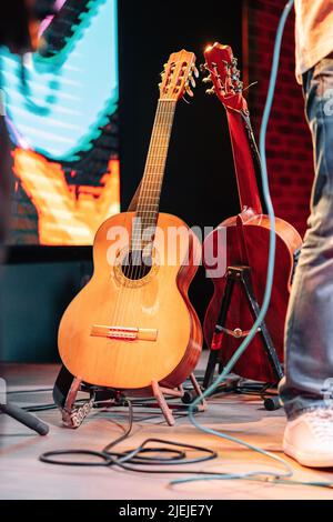 An acoustic guitar on its stand on stage Stock Photo - Alamy