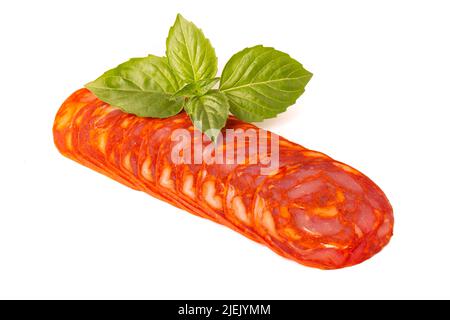 Sliced round pieces of raw-cured Chorizo sausage with basil leaf on a ...