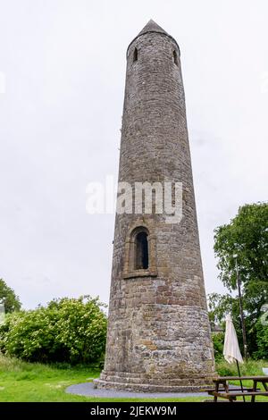 Ireland, County Laois, Timahoe Round Tower partly framed by a wall of a ...
