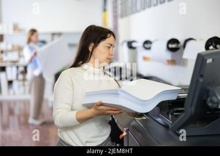 Woman loading ream of paper into printer Stock Photo - Alamy