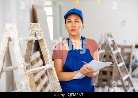 Woman builder checking project documentation Stock Photo - Alamy
